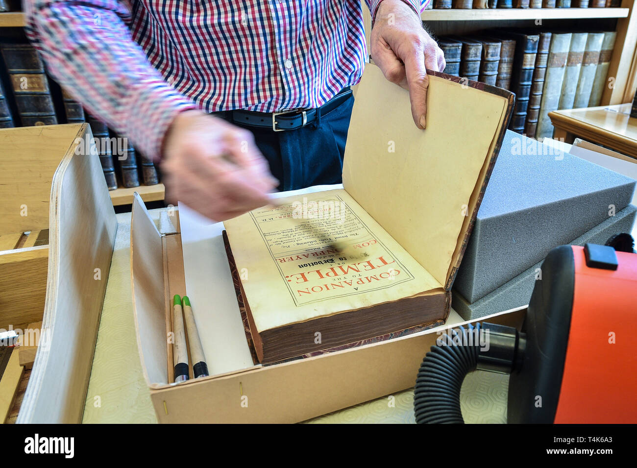 Salisbury cathedral library volunteer Colin Malcolm carefully brushes ...