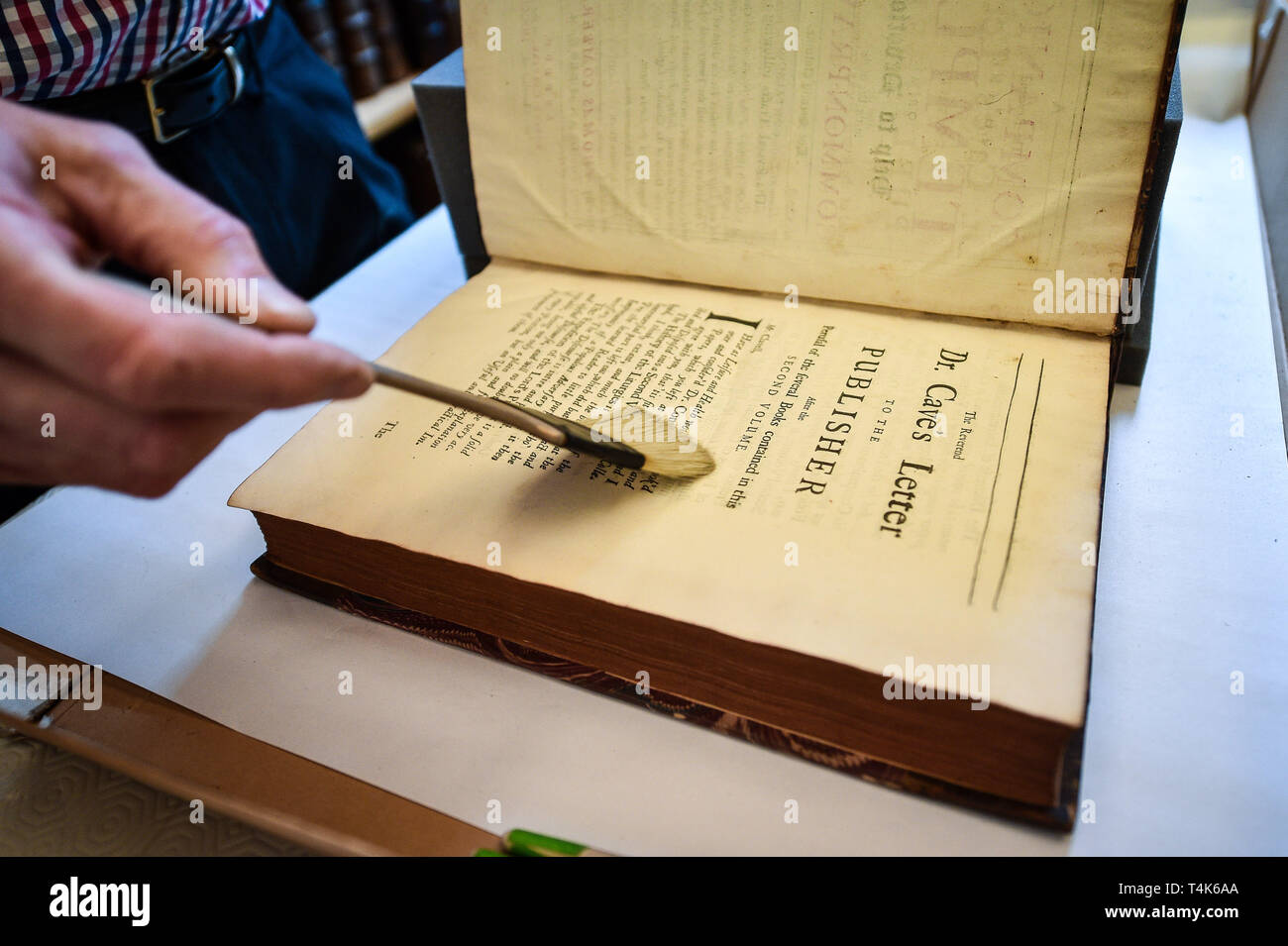 Salisbury cathedral library volunteer Colin Malcolm carefully brushes ...