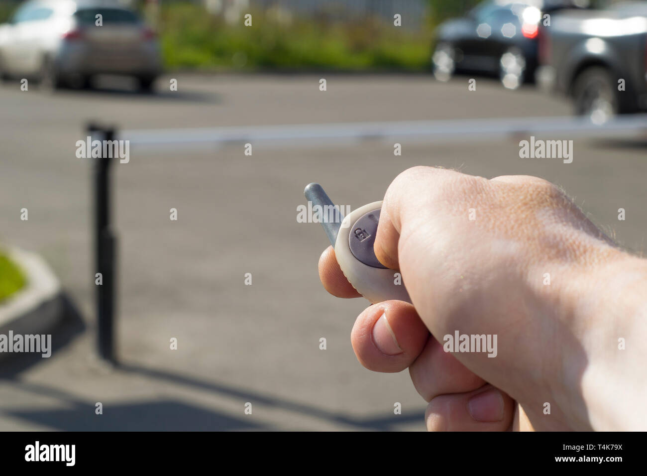 a person with a remote control opens an automatic barrier in the ...