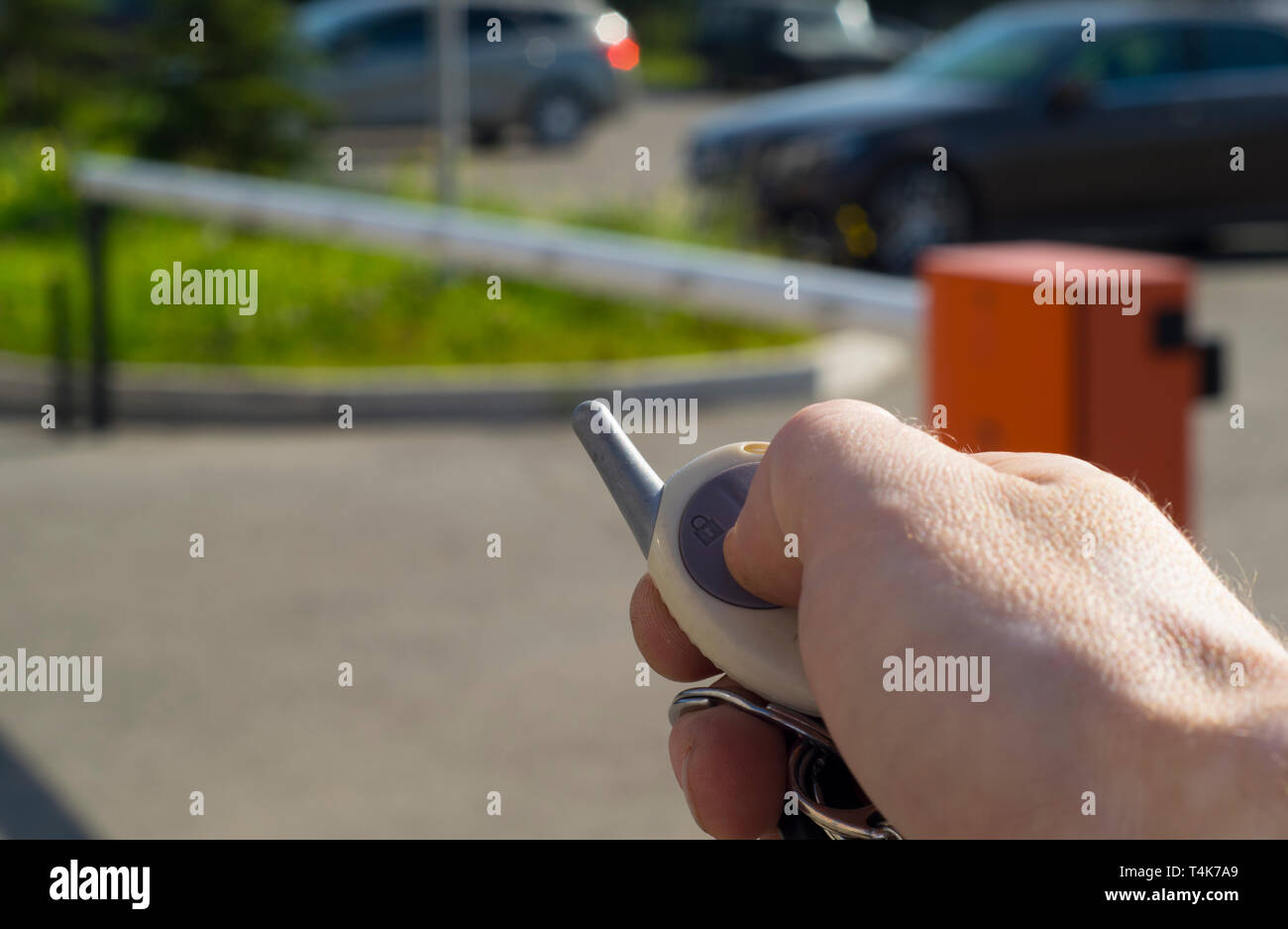 a person with a remote control opens an automatic barrier in the ...
