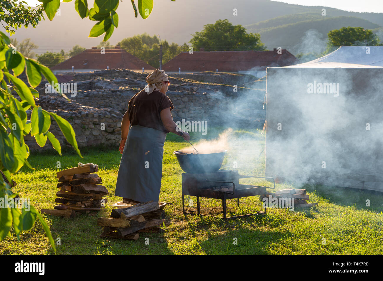 Woman cooking romanian traditional food on fire outdoor in a camping ...