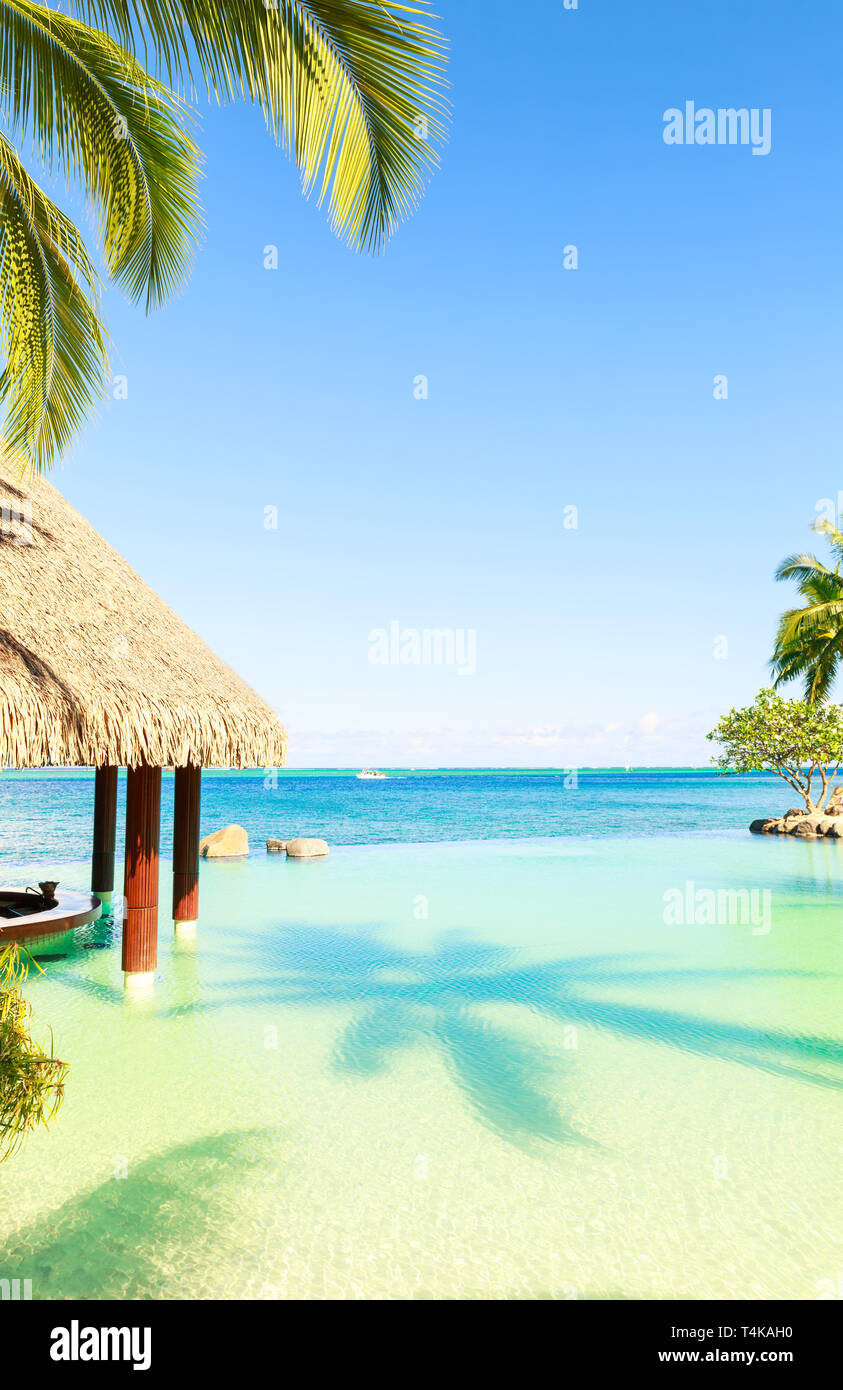 Tiki hut and bar by swimming pool of luxury hotel on a bright sunny day ...