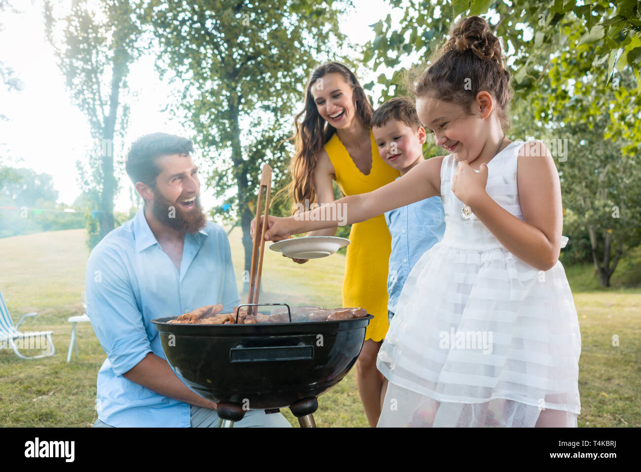 Cute funny girl preparing meat on BBQ charcoal grill Stock Photo - Alamy
