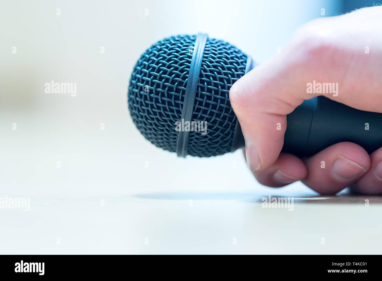 Close up picture of a hand which is holding a black microphone Stock ...