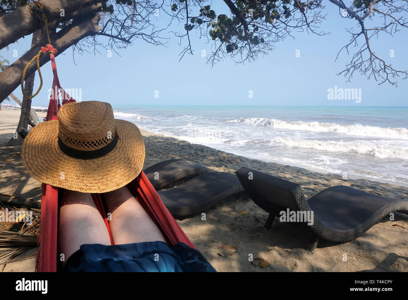 Sun Hat on the Feet of a Woman Relaxing in a Hammock with Ocean Views ...