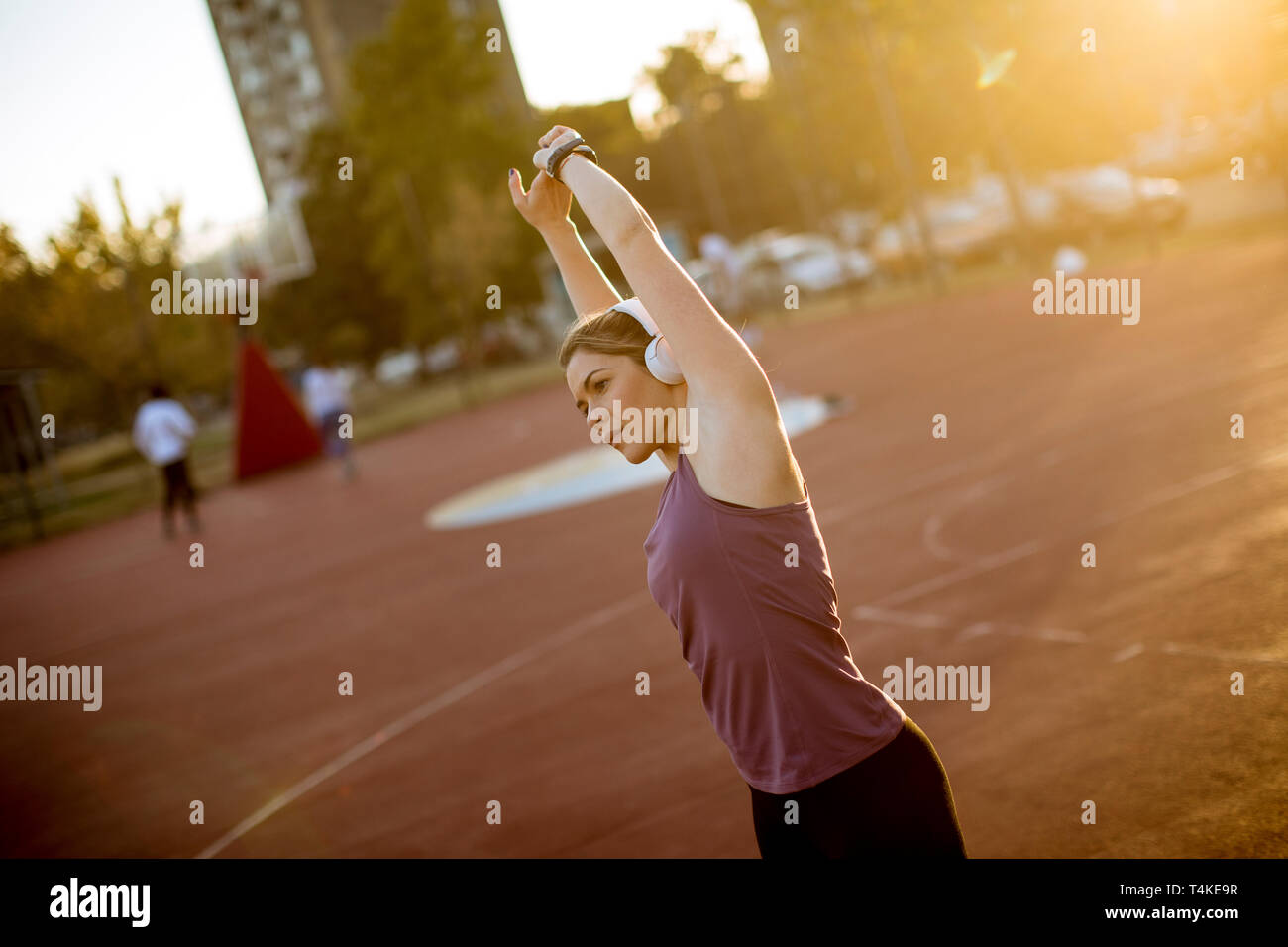 Slender fit blonde woman doing stretching before workout on court Stock ...
