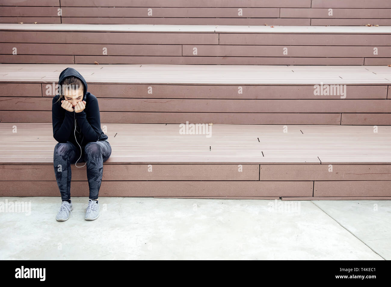 Sad and frustrated sporty young woman sitting alone outdoor Stock Photo ...