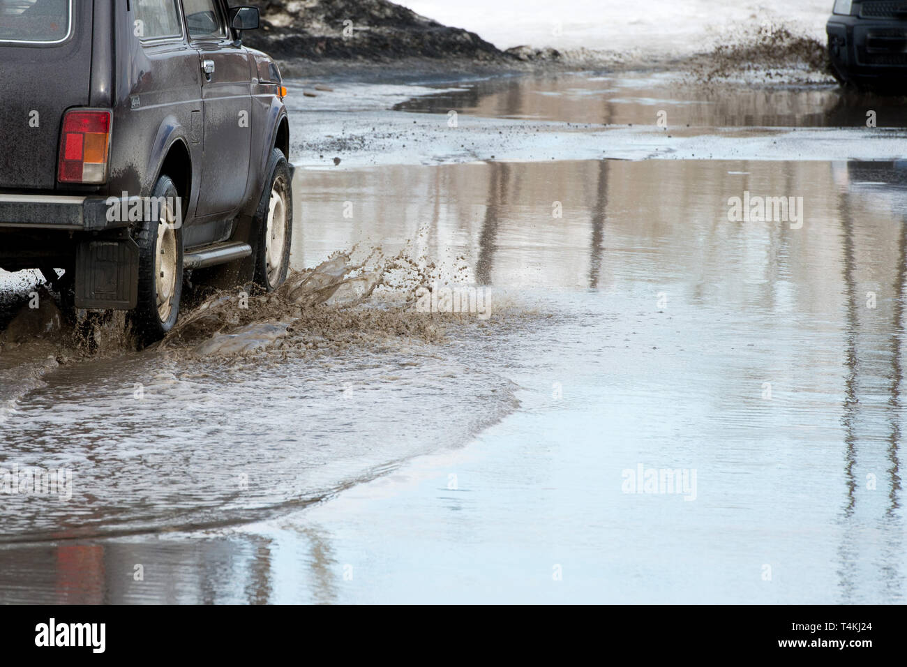 dirty wave of spray from under the wheels of a truck. Water on the road ...