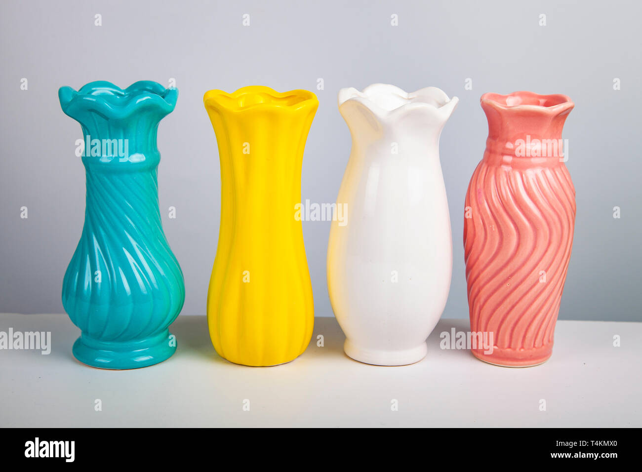 Four multi-colored vases on a light background Stock Photo - Alamy