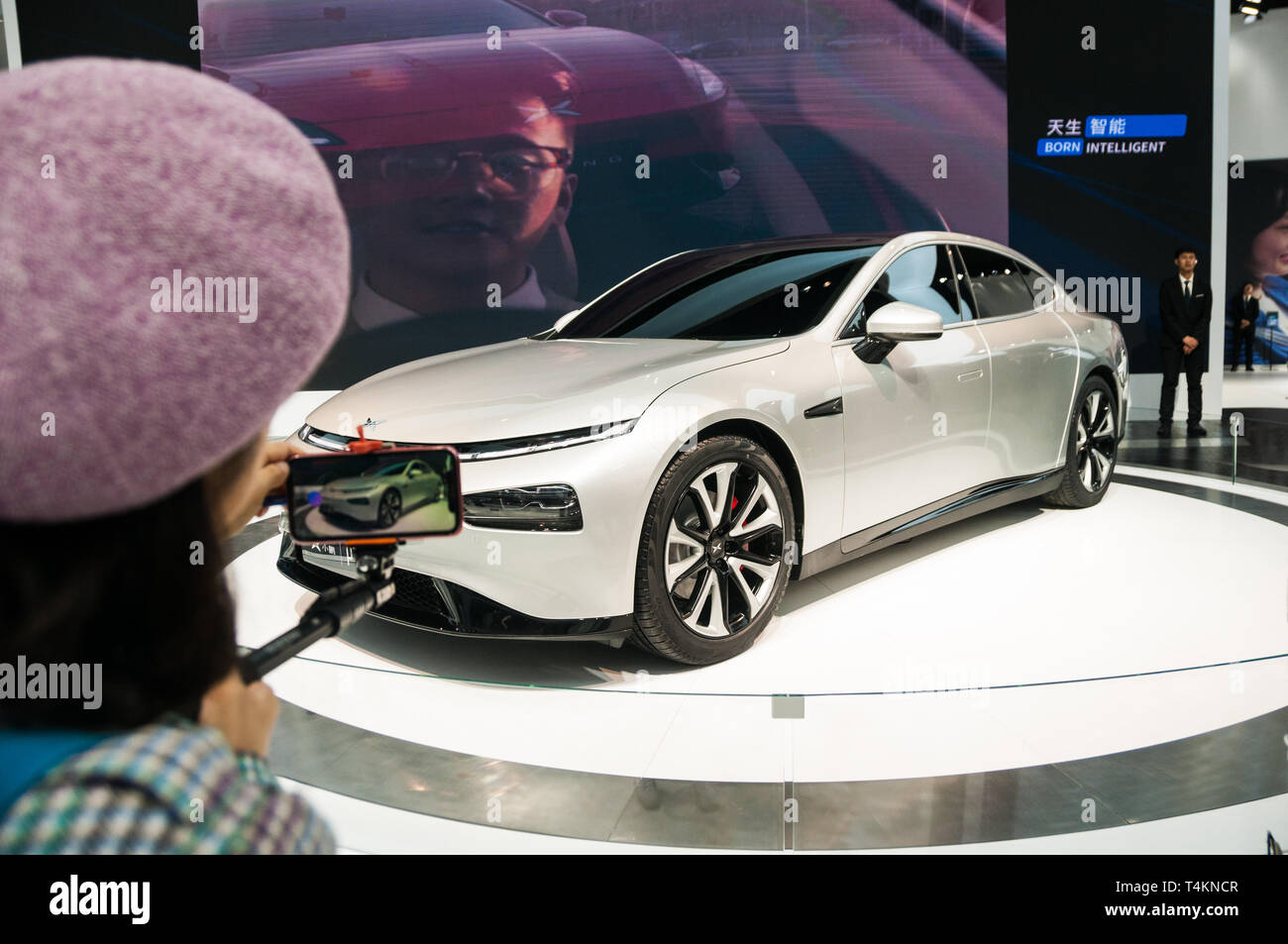 A girl takes a picture of the Xpeng X7 using a smartphone and selfie ...