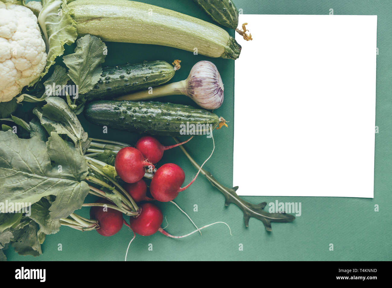 Top view of various vegetables lying on a table on a green background ...