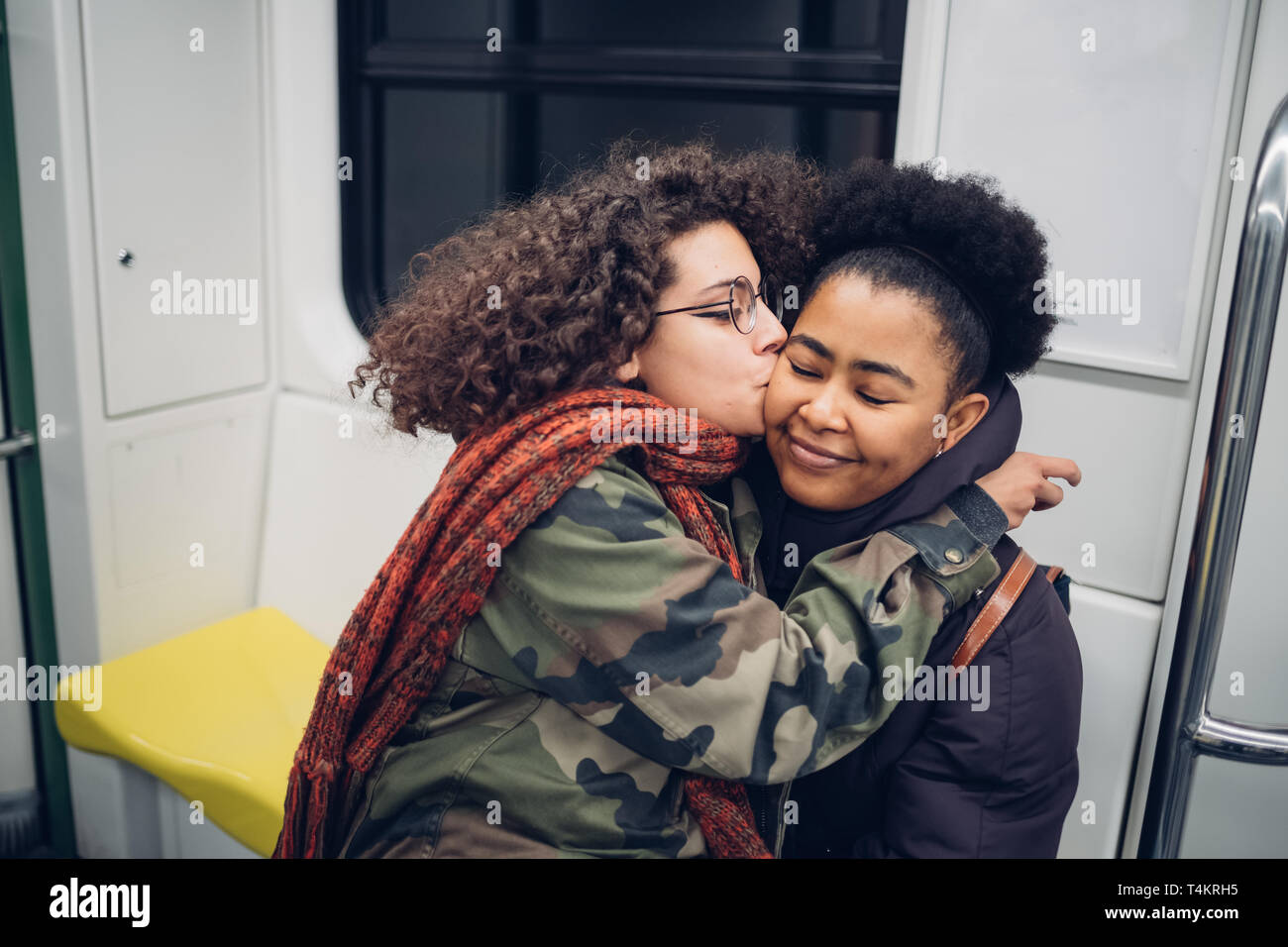 two friends kissing in the metro and hugging – traveling, metropolitan ...