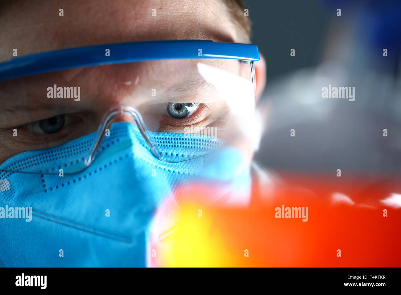 Laboratory man wearing protective mask hold in hand test sample Stock ...