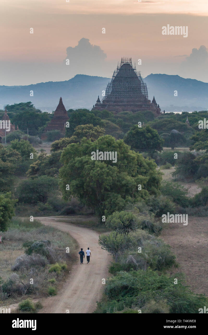 Two men walk the road to Old Bagan at sunset, Myanmar Stock Photo - Alamy
