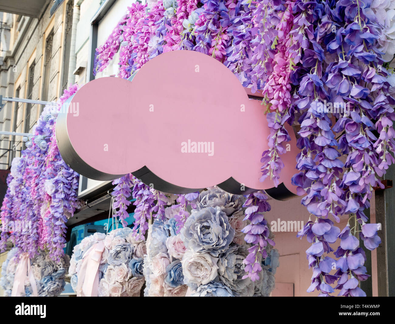 blank pink color signboard in shape of a cloud with hanging flowers ...