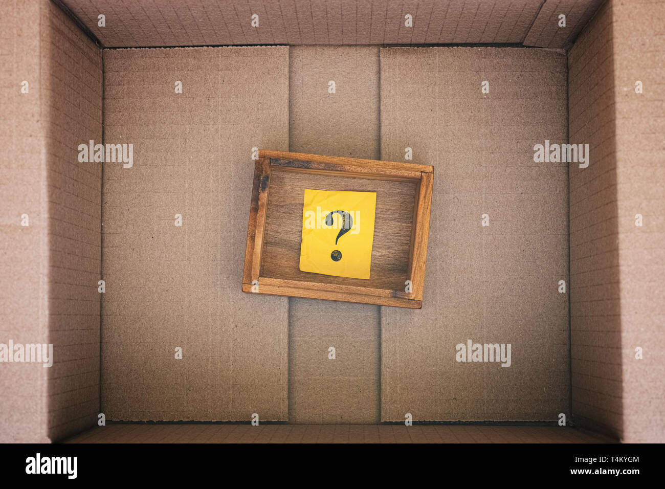 Wooden box with question mark inside cardboard box. Concept image ...