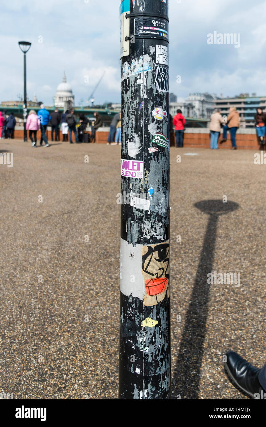 A lampost covered in stickers and the remains of stickers Stock Photo ...