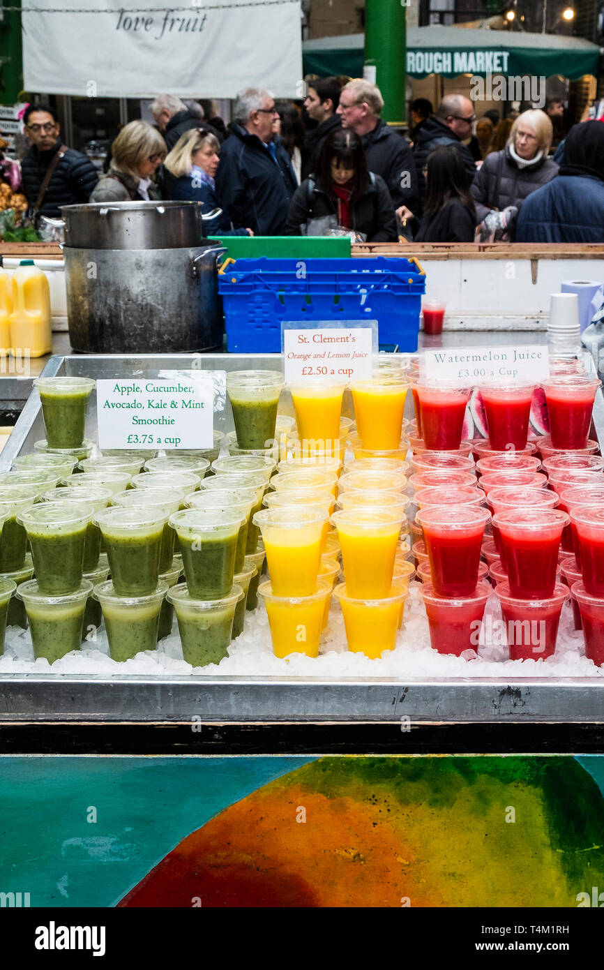 Plastic cups of various fruit juices on sale at Borough Market in ...