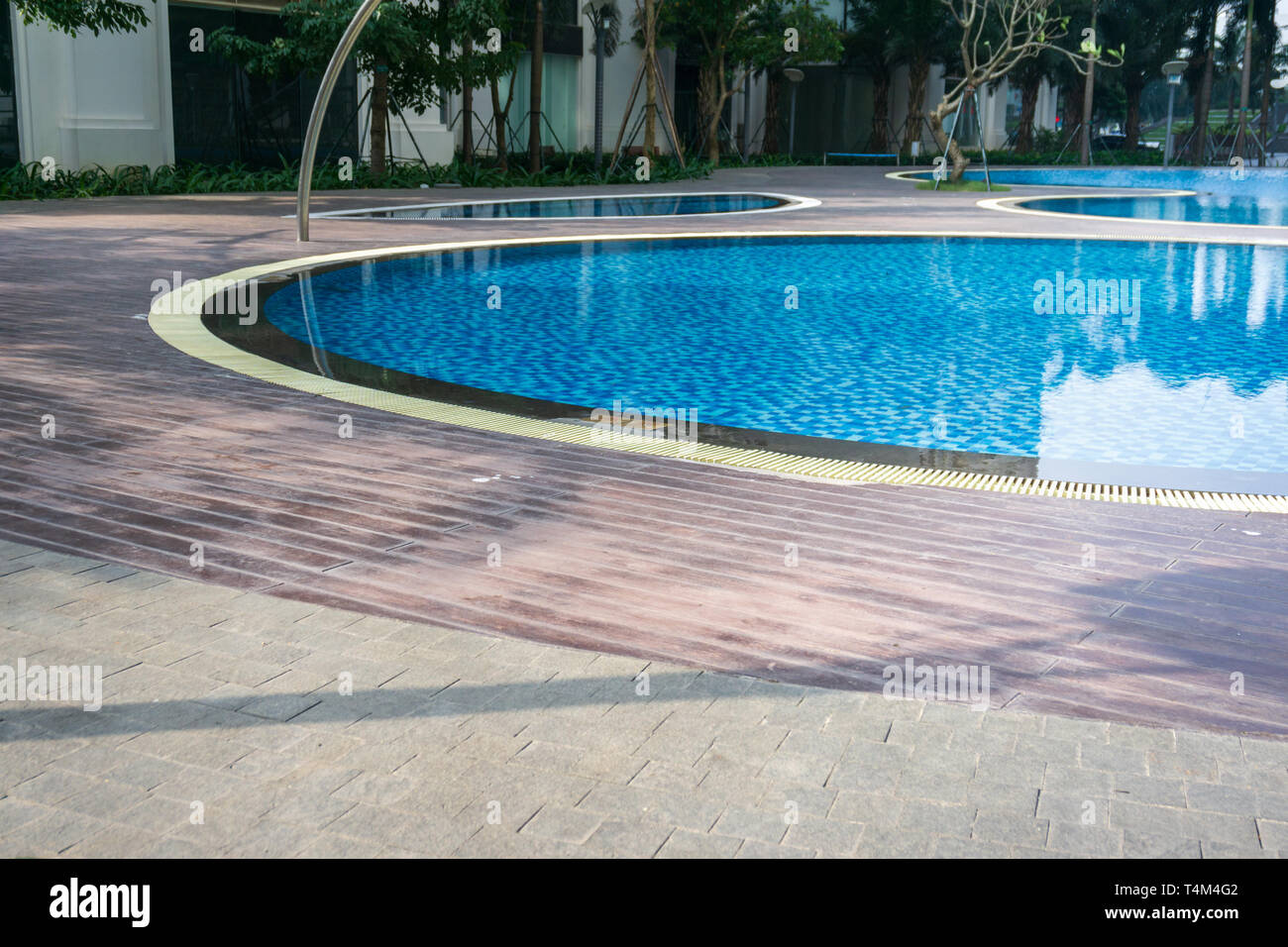 Blue swimming pool with wood flooring stripes Stock Photo - Alamy