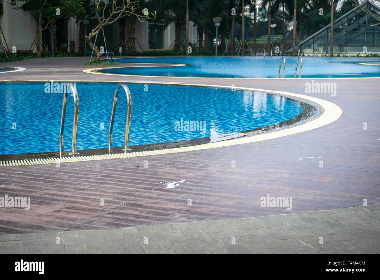 Blue swimming pool with wood flooring stripes Stock Photo - Alamy