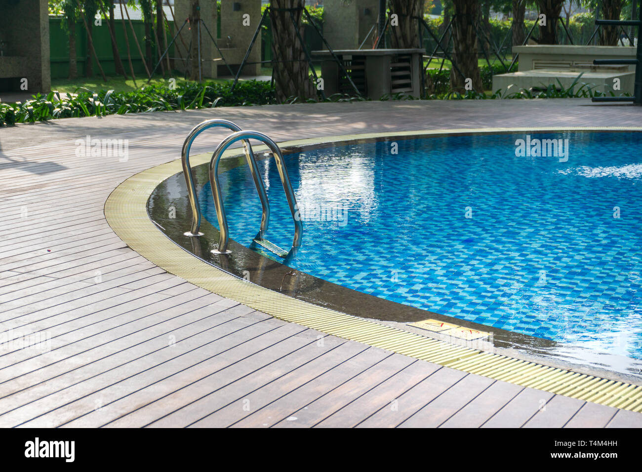 Blue swimming pool with wood flooring stripes Stock Photo - Alamy