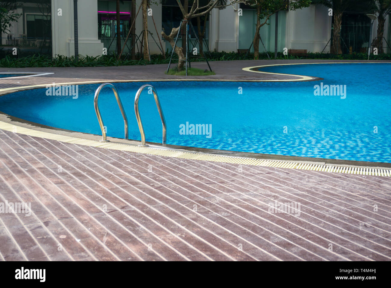 Blue swimming pool with wood flooring stripes Stock Photo - Alamy