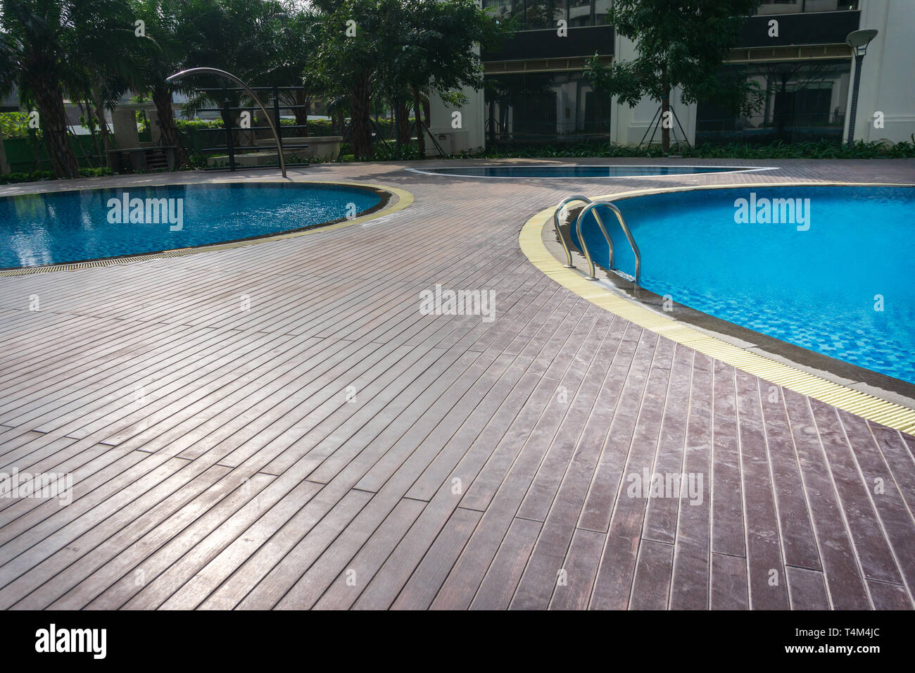 Blue swimming pool with wood flooring stripes Stock Photo - Alamy
