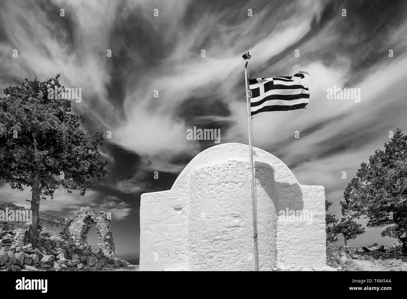 The apse of a typical Greek church with the flag in the wind among the ...