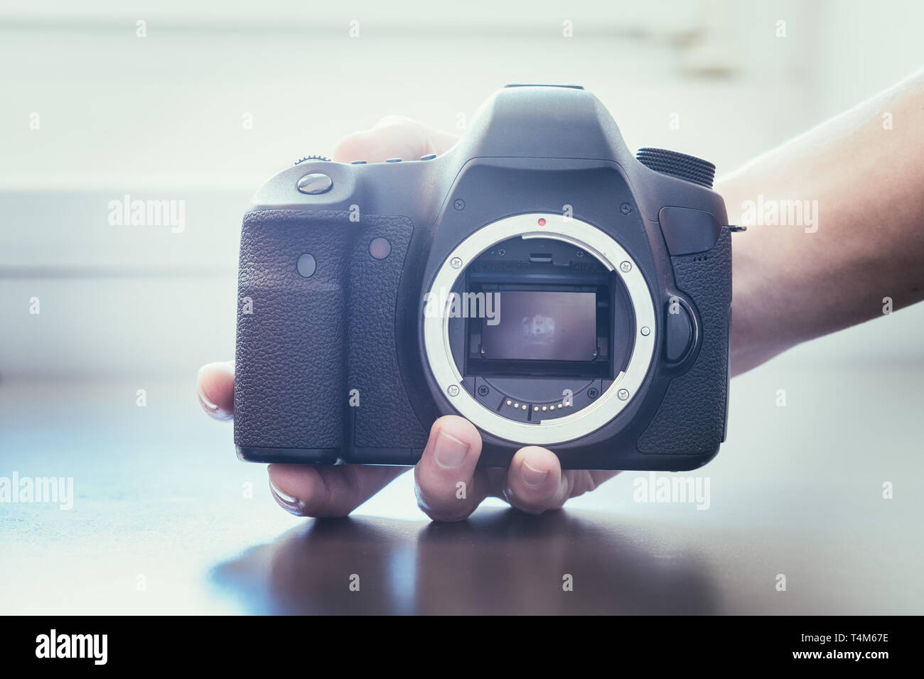 Hands of a photographer are touching a professional reflex camera, open ...