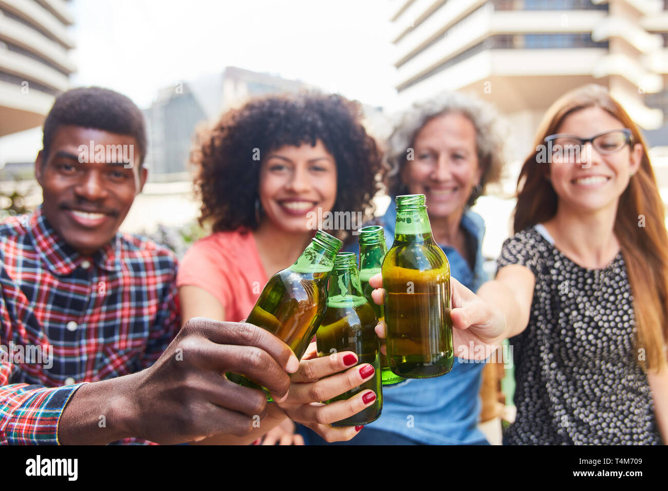 Colleague team drinks beer together at closing time on the office roof ...