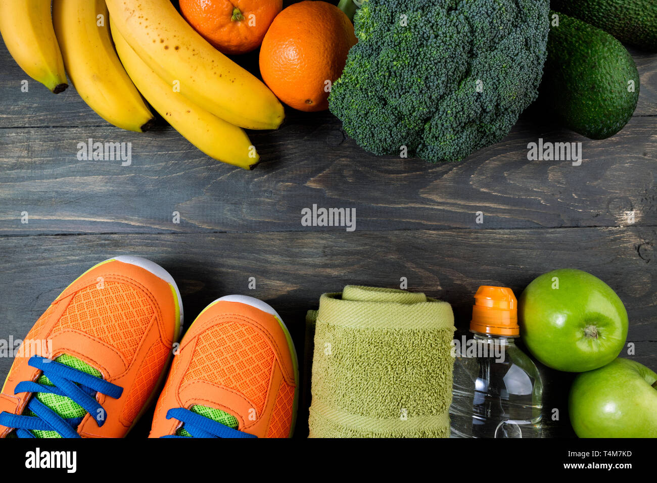 Sport shoes, bottle of water, fruits and vegetables on wooden ...