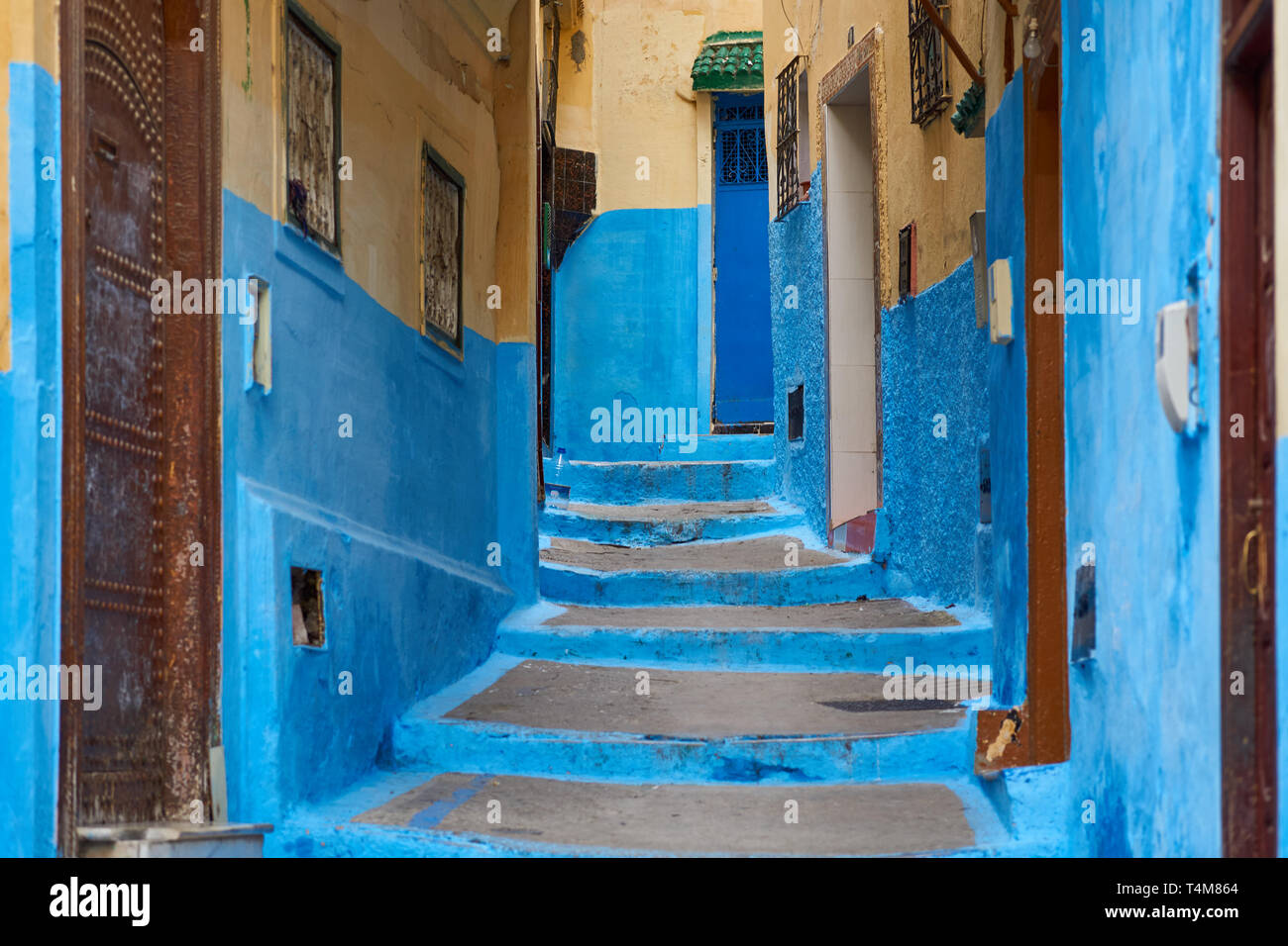 Typical blue painted alley with old door entrance in the medina of ...