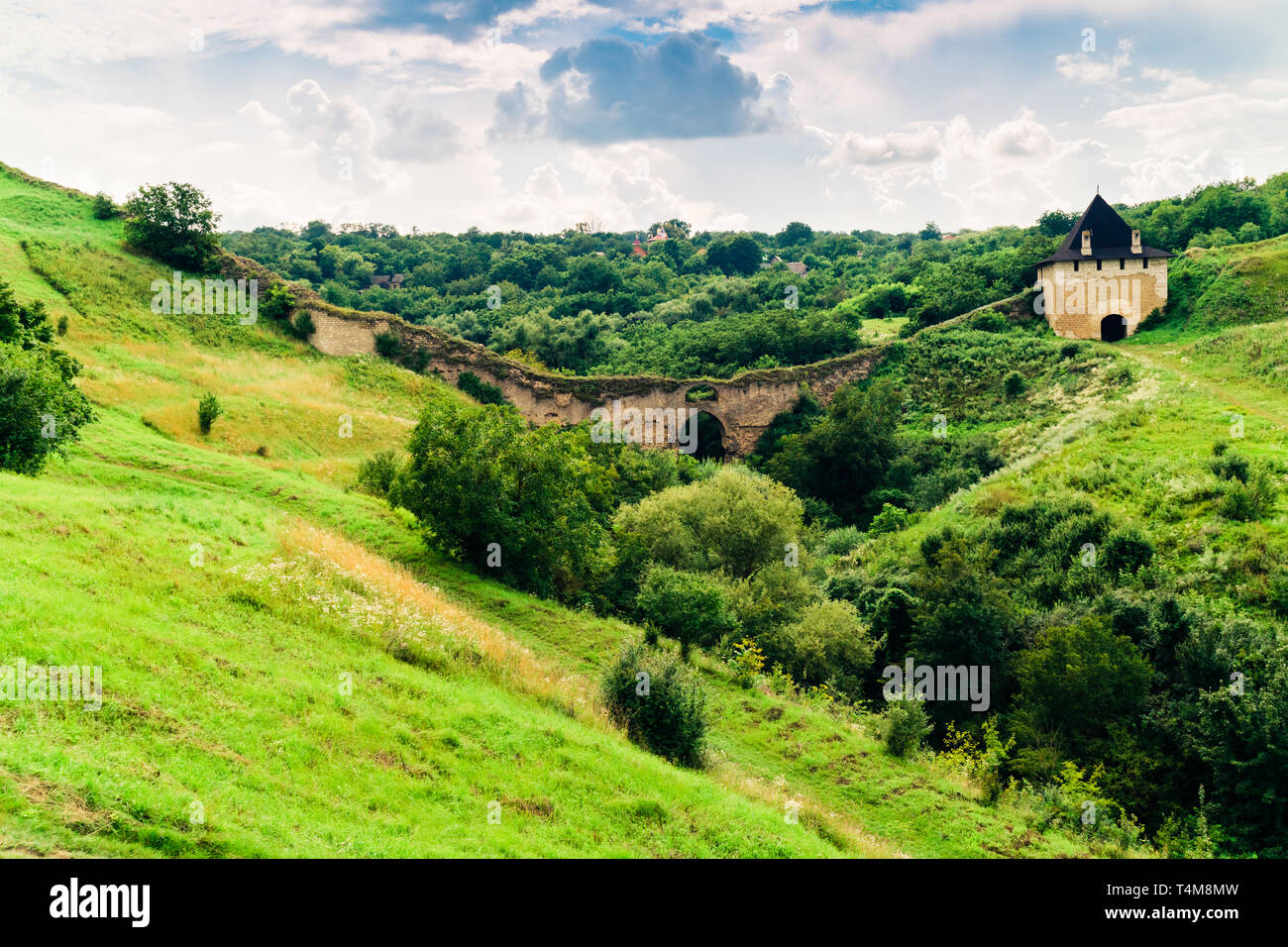 Summer view of green hills and old watchtower ruins. Khotyn Fortress ...