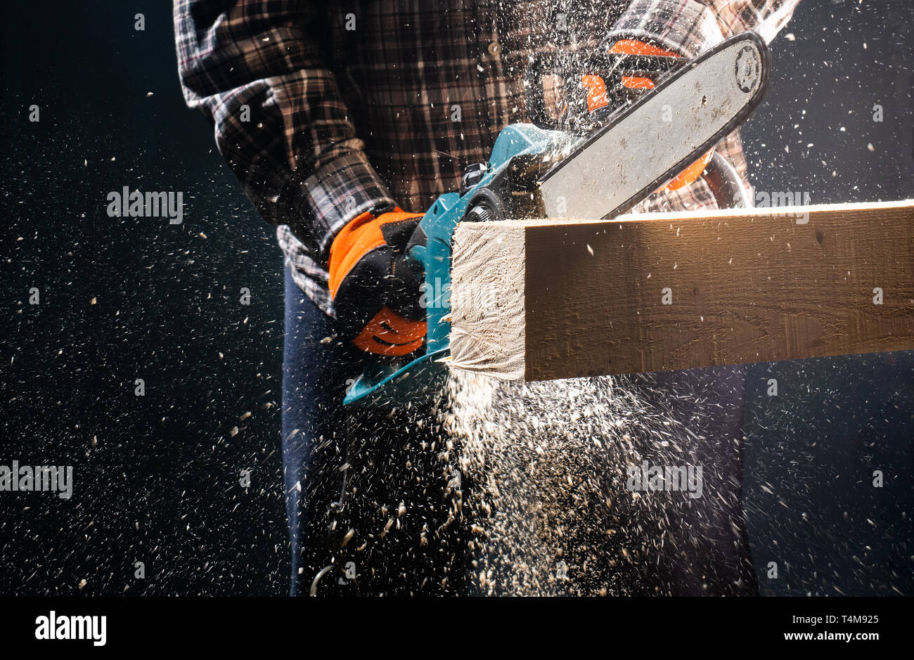 Man using modern electric circular saw for ctting wood in the workshop ...
