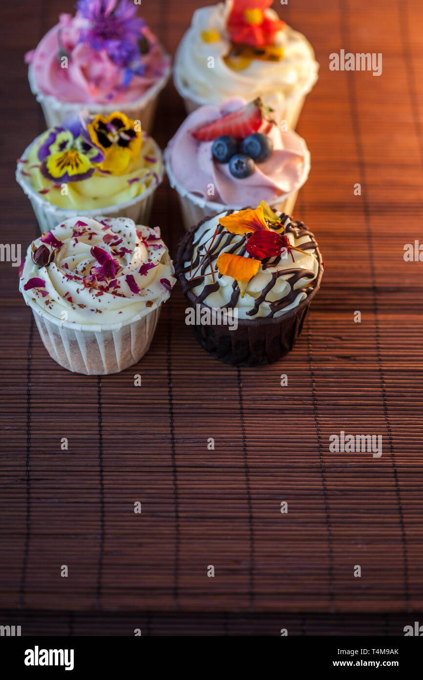 Beautiful and delicious cupcakes on the table. A set of delicious sweet ...