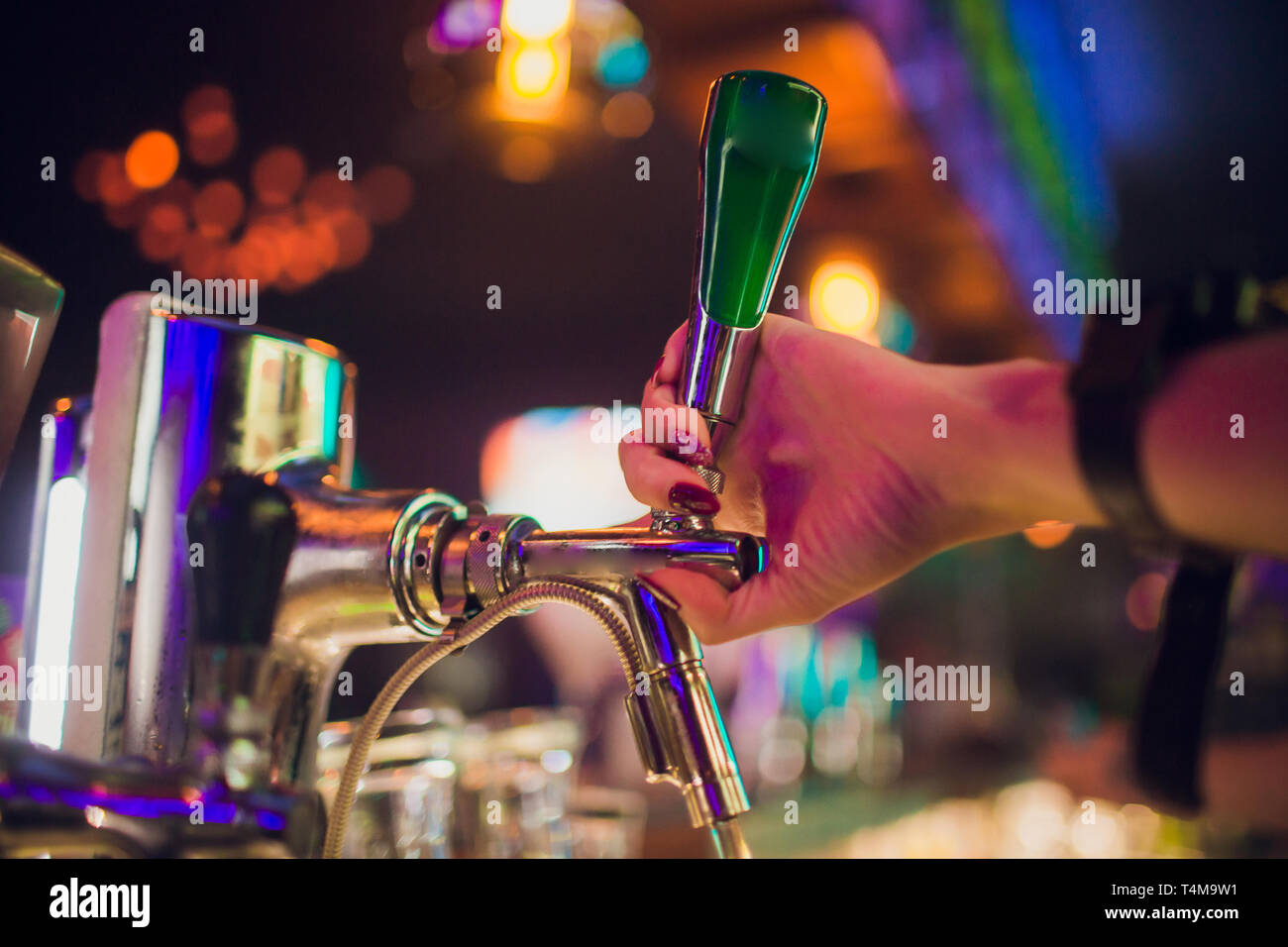 We meet oktoberfest. Hand of bartender pouring a large lager beer in ...