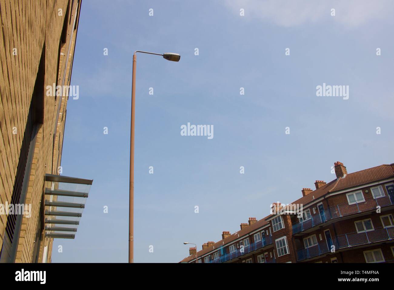 Modern building on one side of image and top floor of council flats on ...