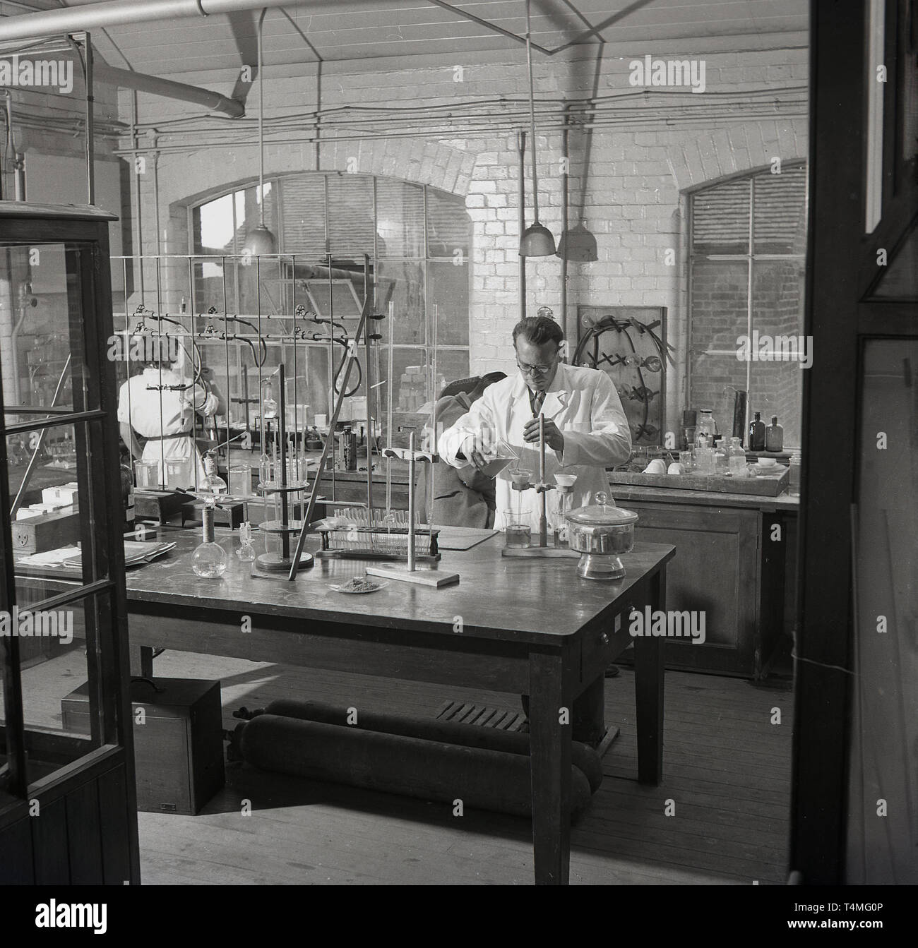 1950s, historical, white-coated staff working in the research labatory ...