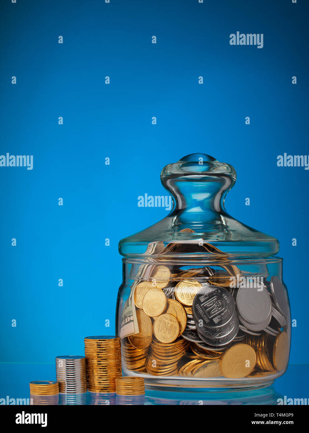 Glass with coins Stock Photo - Alamy