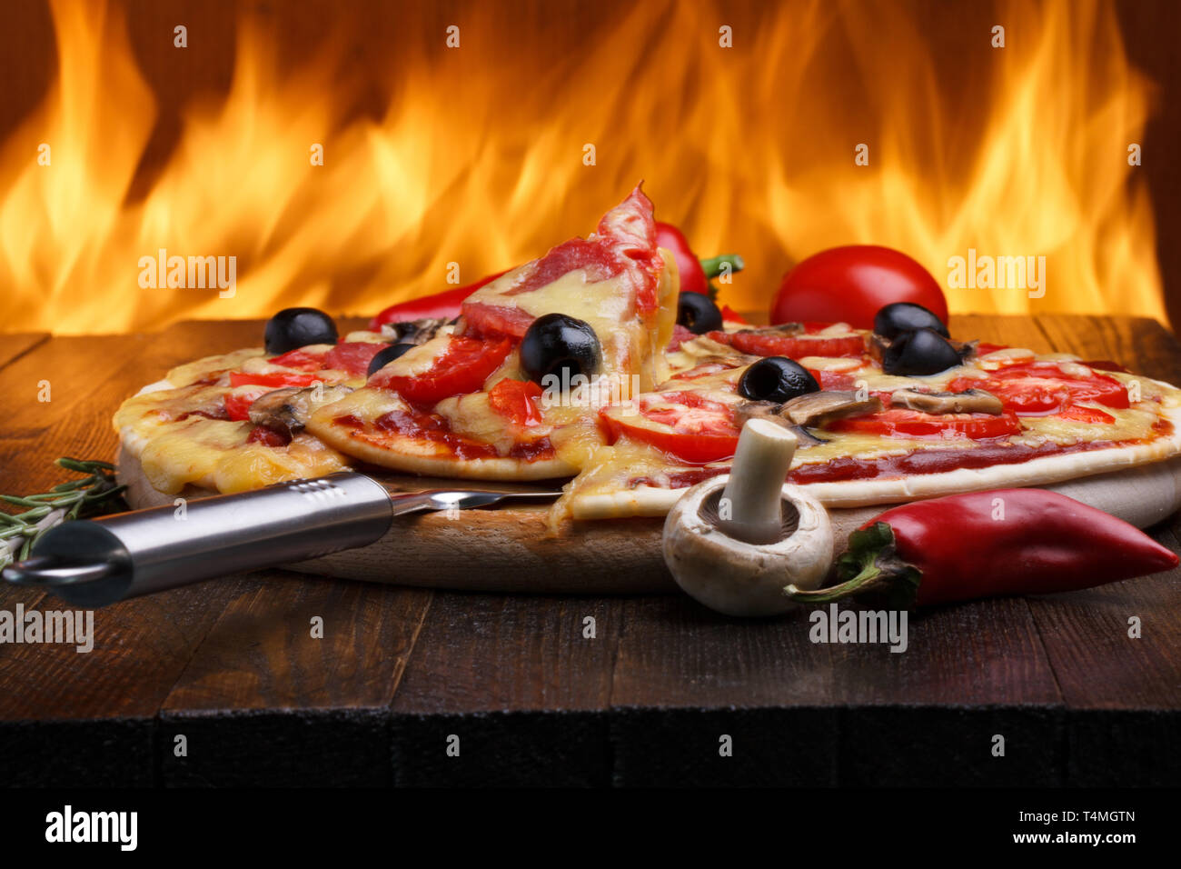 Hot pizza with oven fire on background Stock Photo - Alamy