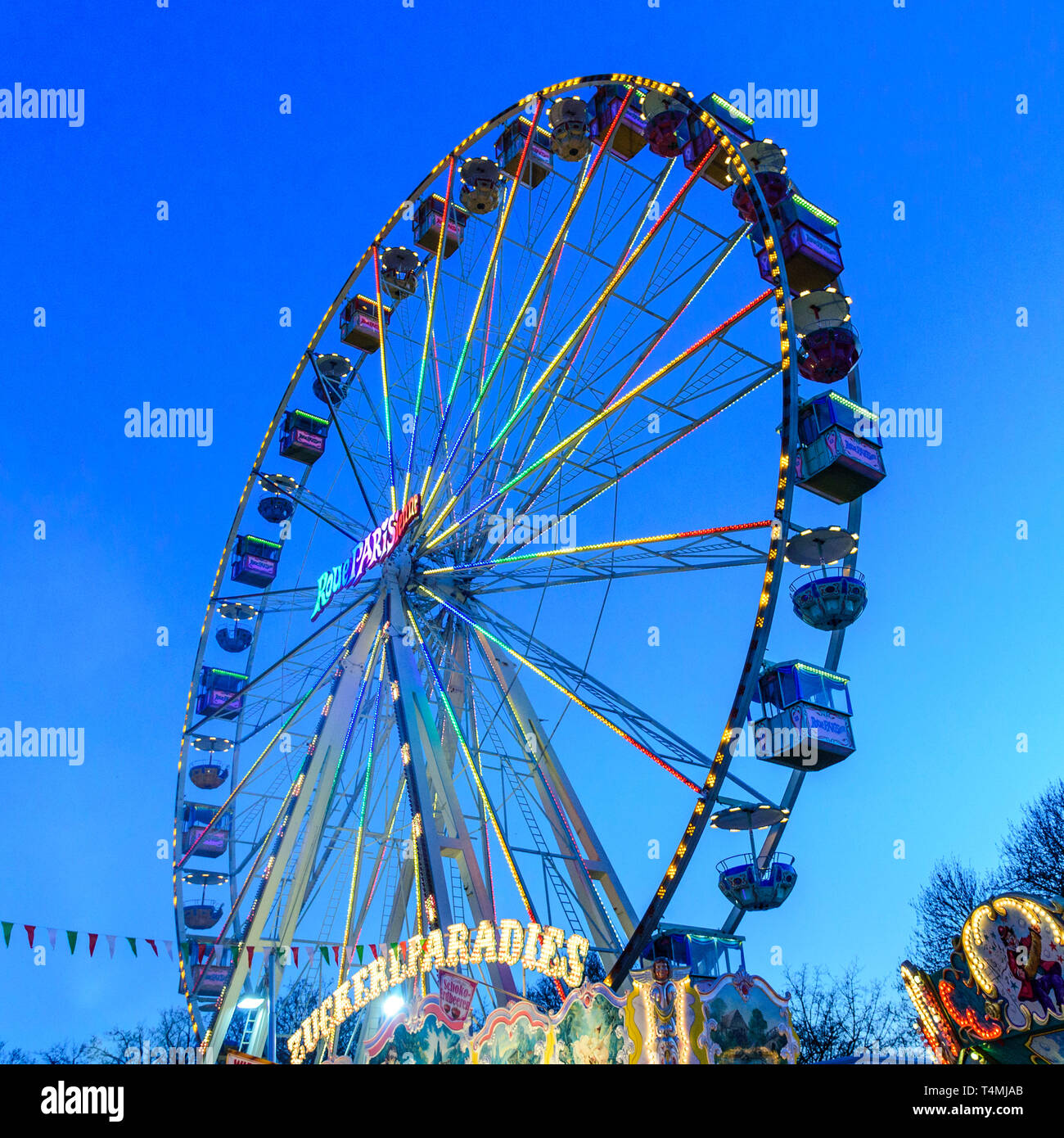 Colorful illuminated fairground attractions - ferris wheel Stock Photo ...
