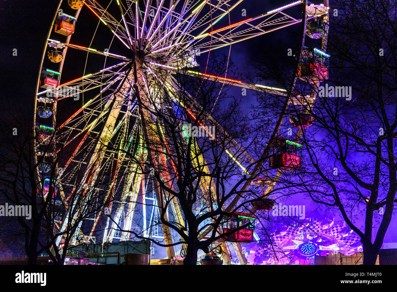 Colorful illuminated fairground attractions - ferris wheel Stock Photo ...
