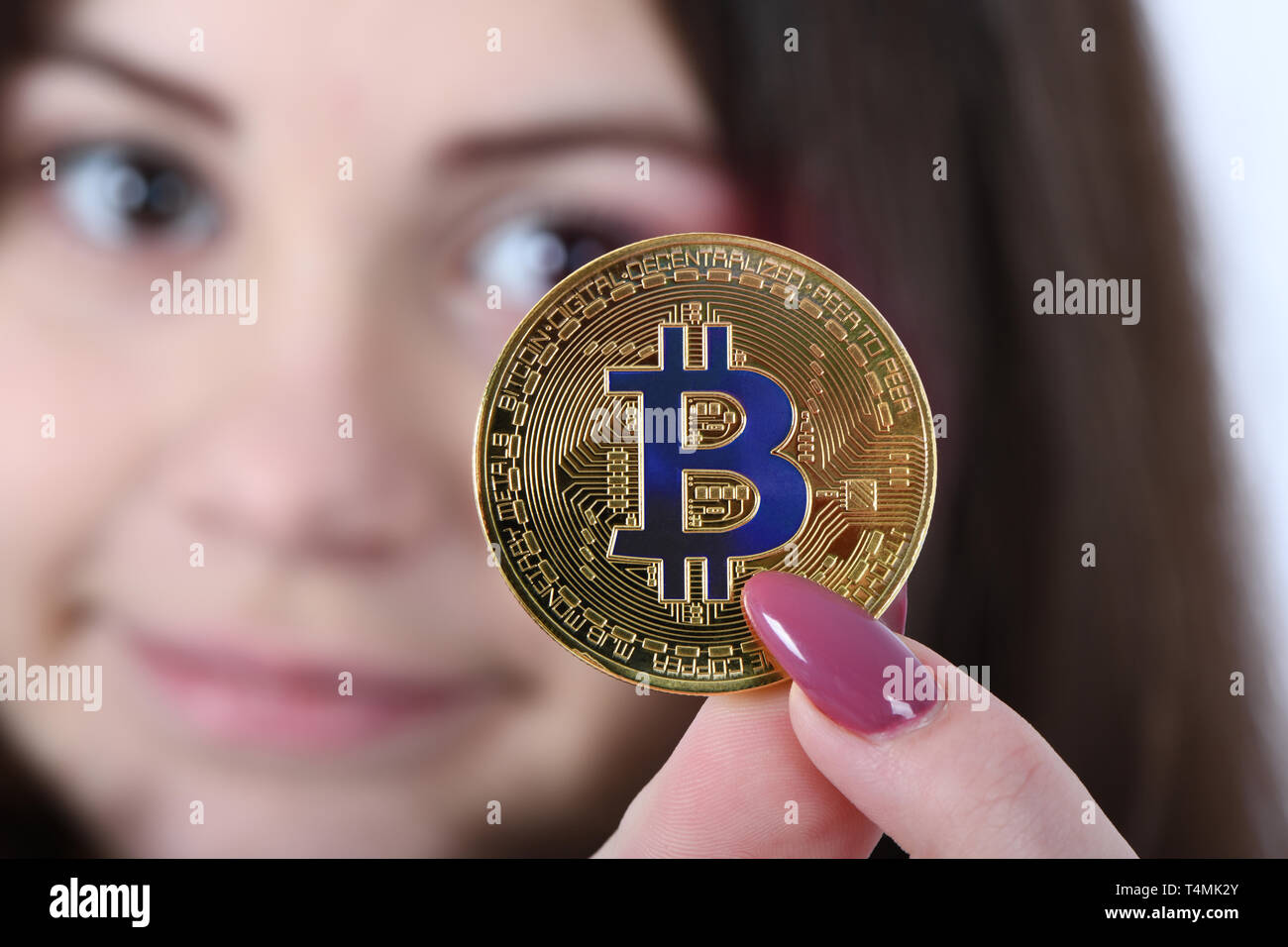 Pretty Girl holding in front of her new golden cryptocurrency bitcoin ...