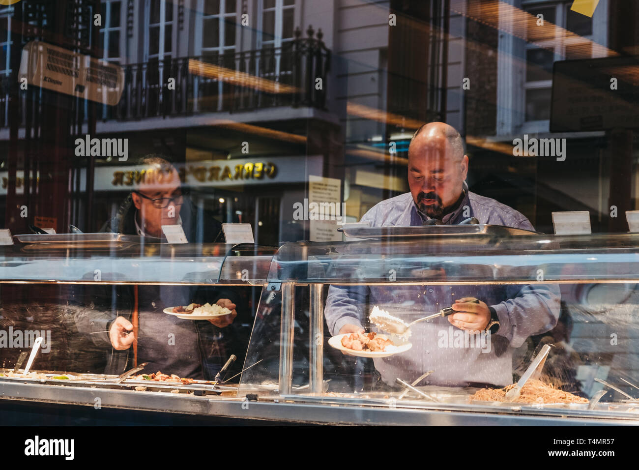London, UK - April 13, 2019: Customers seen through the window of ...