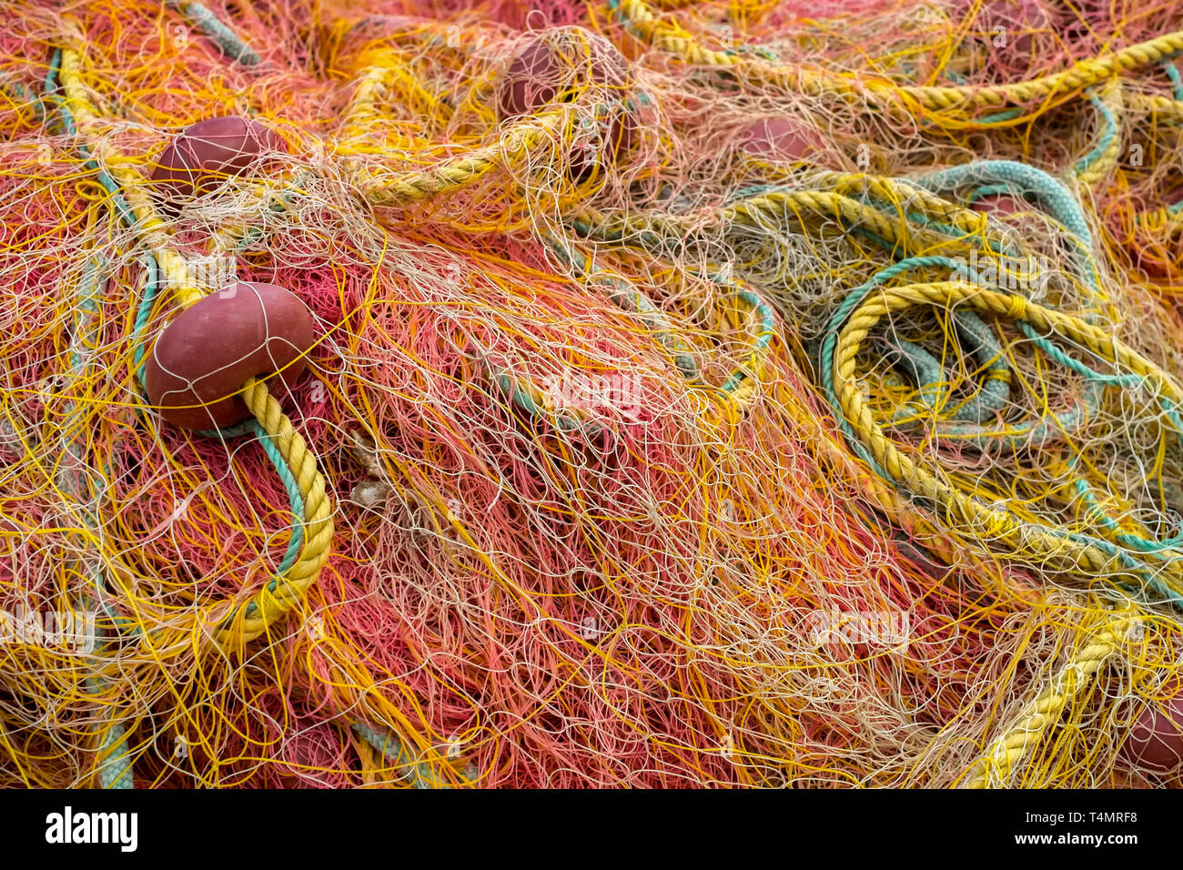 Colourful fishing net with ropes and red floats Stock Photo - Alamy