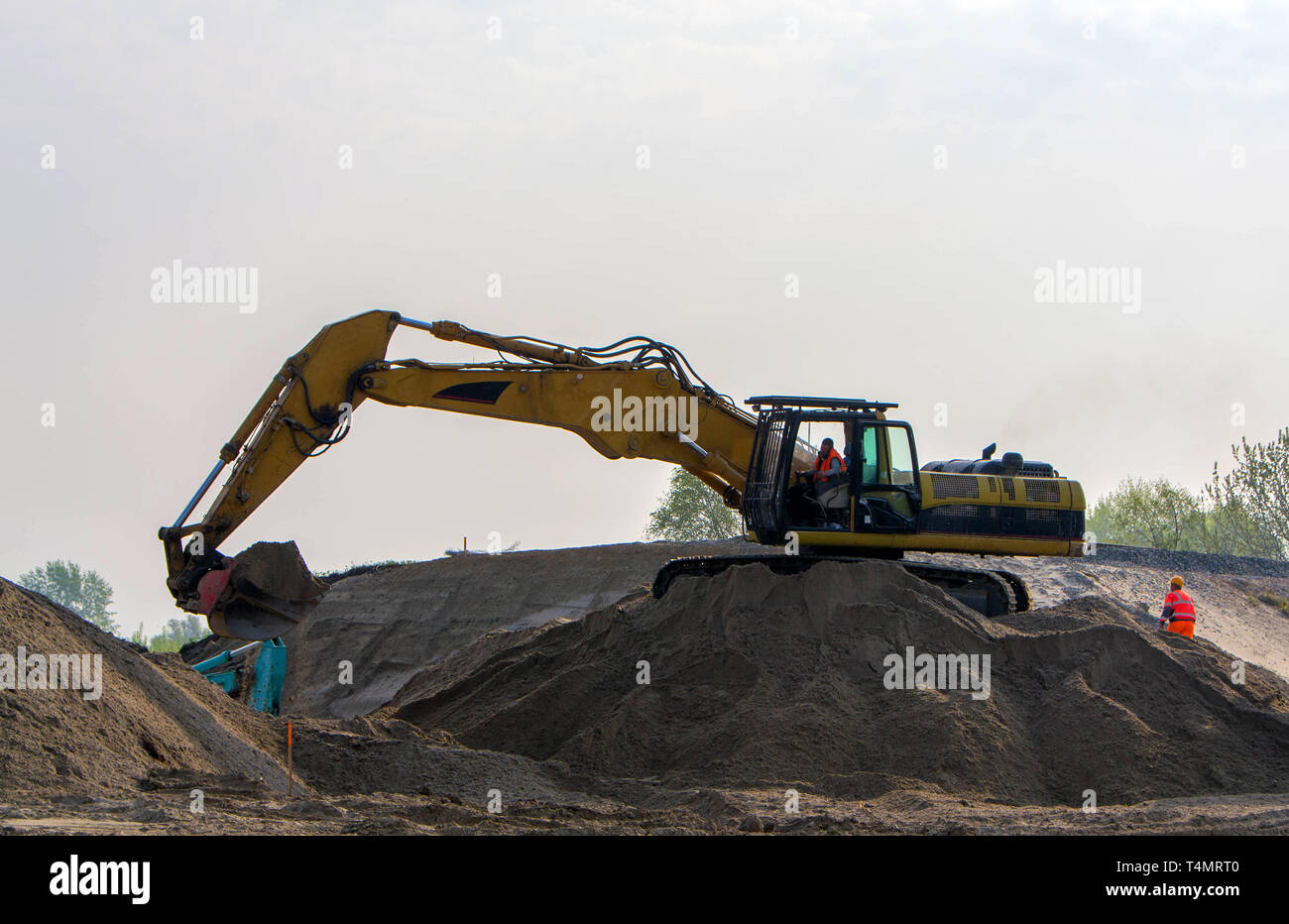 Excavator loading sand in the truck on the construction of access roads ...