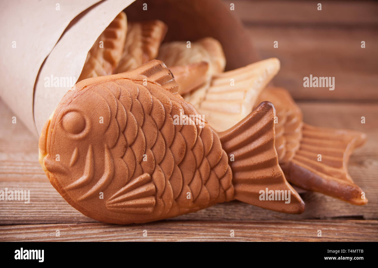 Taiyaki Japanese street food fish-shaped sweet waffle on wooden table ...