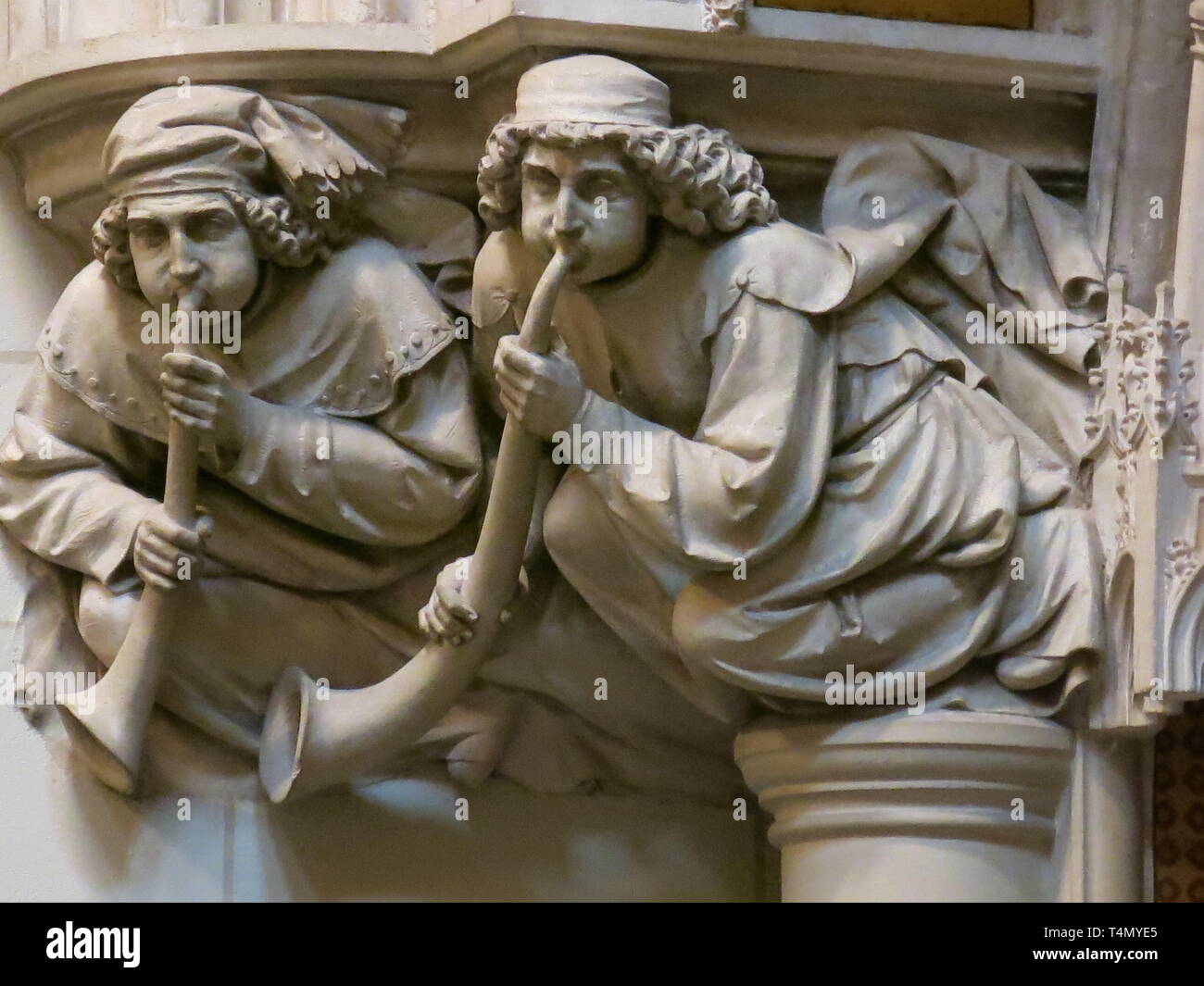 Close-up of two statues (figures blowing trumpets) inside the ornate ...