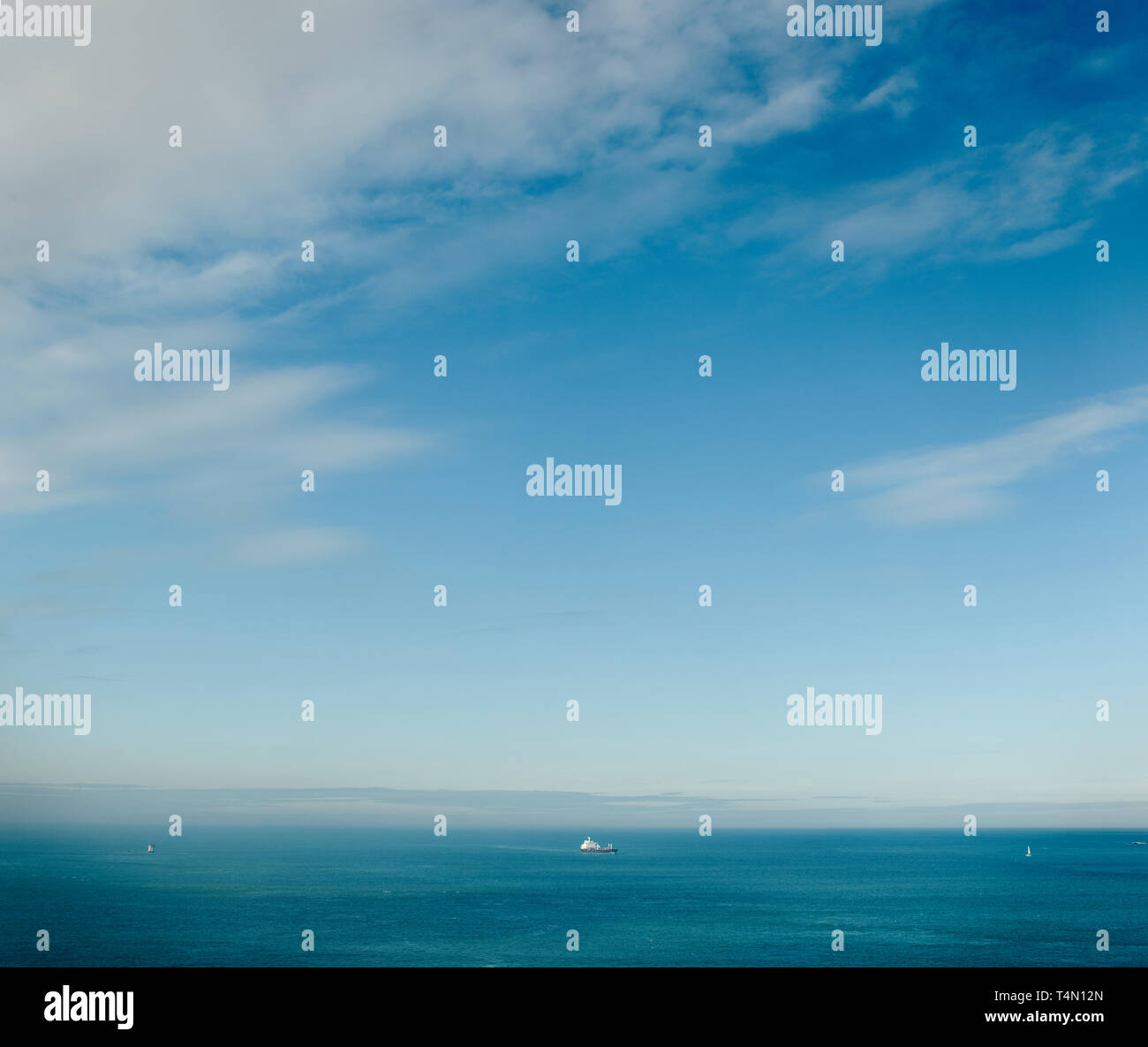 Cargo ship and a sailboat in a vast open sea Stock Photo - Alamy