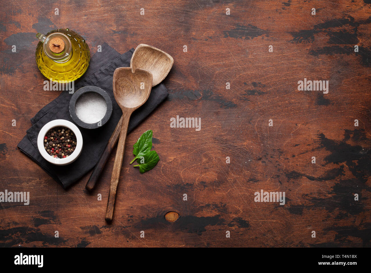 Cooking wooden utensils, condiments and spices on wooden kitchen table ...